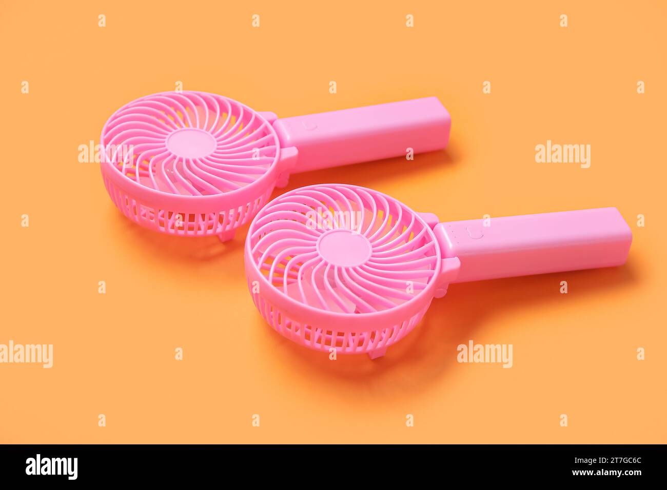 Portable pink electric fans on orange background, closeup Stock Photo ...