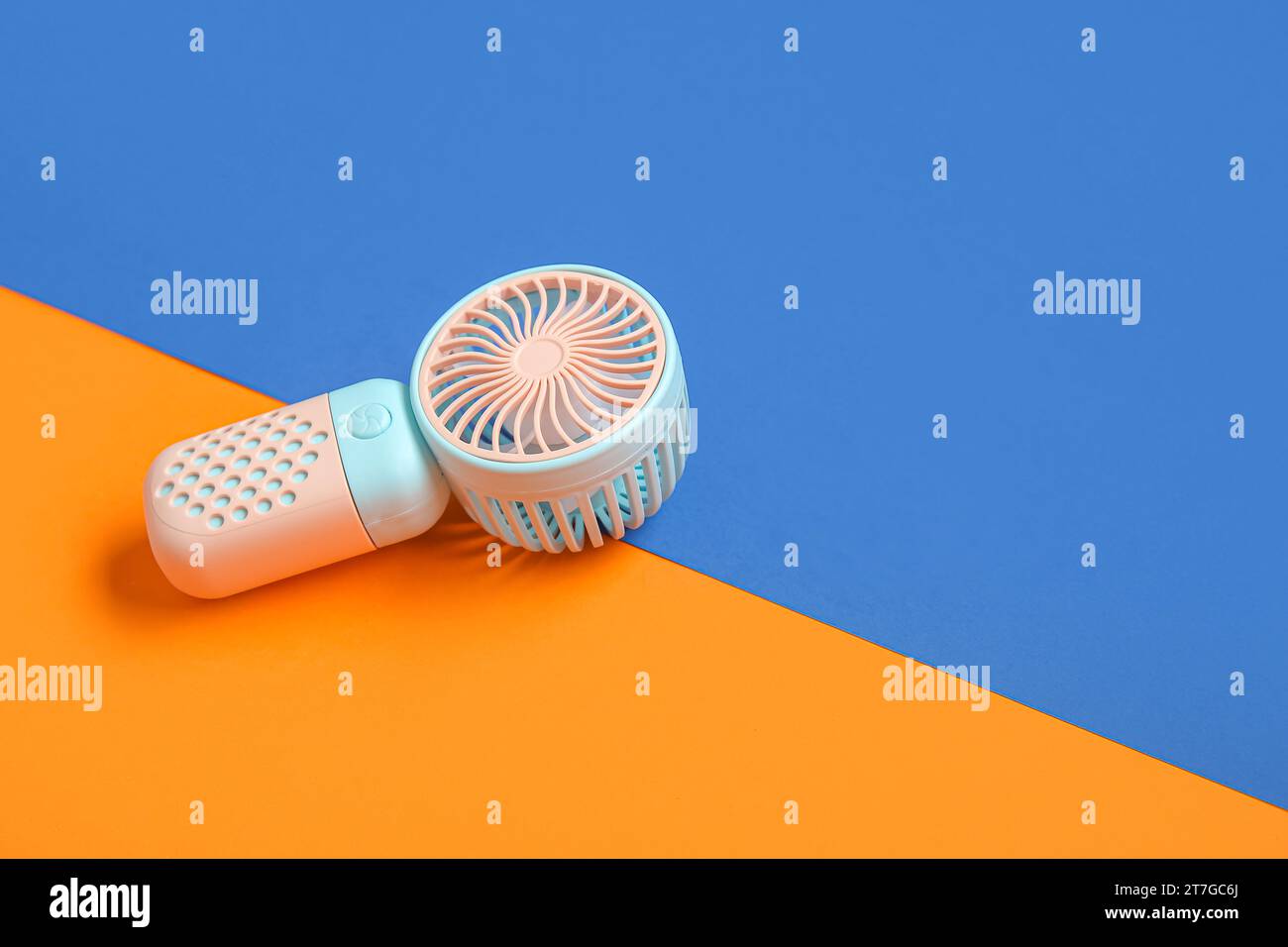 Small new electric fan on color background Stock Photo - Alamy
