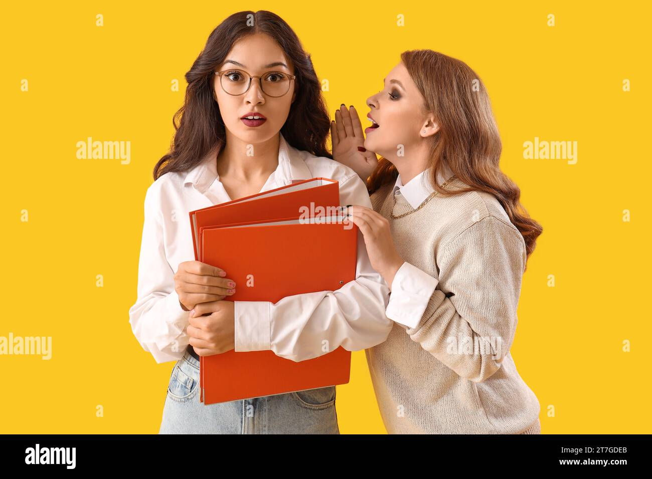 Business colleagues gossiping on yellow background Stock Photo - Alamy