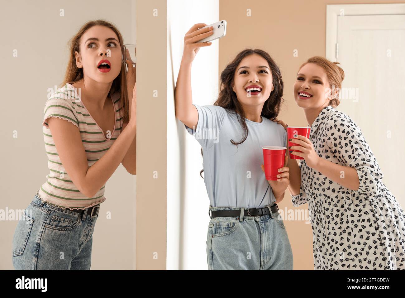 Young woman eavesdropping on her neighbours at home Stock Photo - Alamy