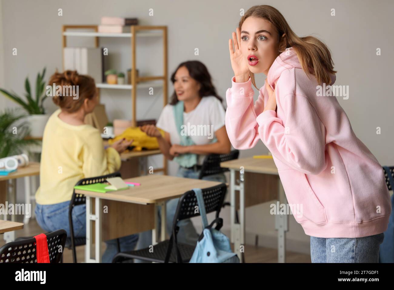 Female student trying to hear something in classroom Stock Photo - Alamy