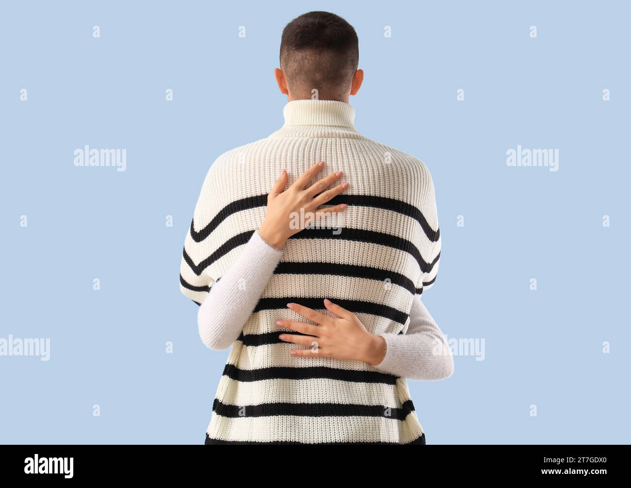 Young couple hugging on blue background, back view Stock Photo - Alamy