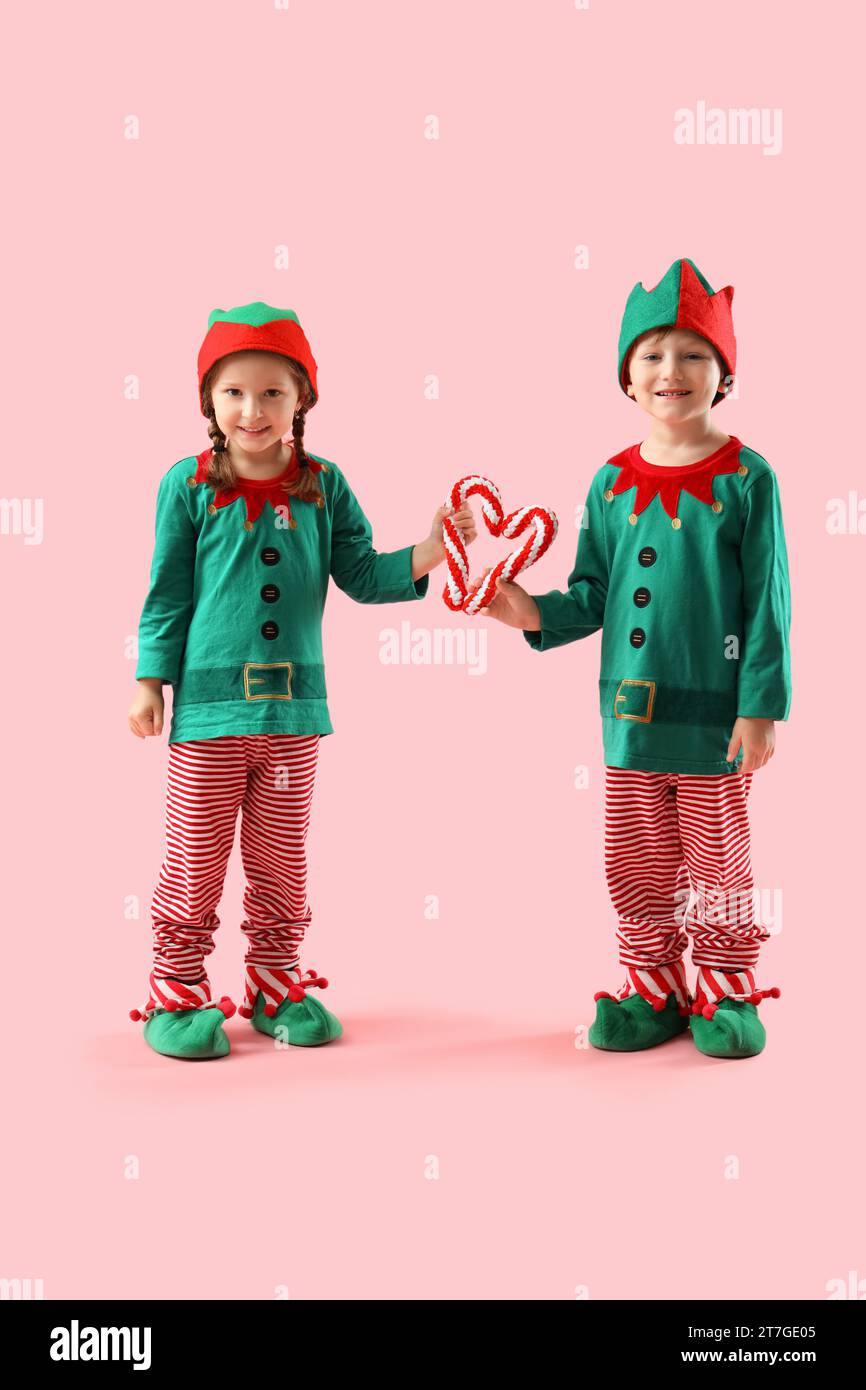 Cute little elves with candy canes on pink background Stock Photo - Alamy