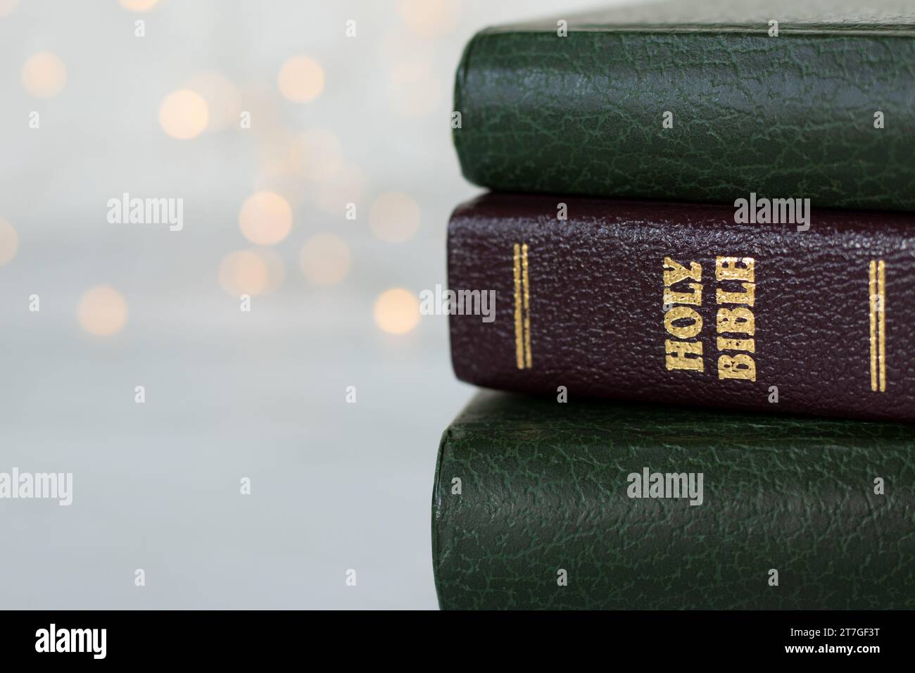 Stack of books with holy bible in the middle isolated on white with ...