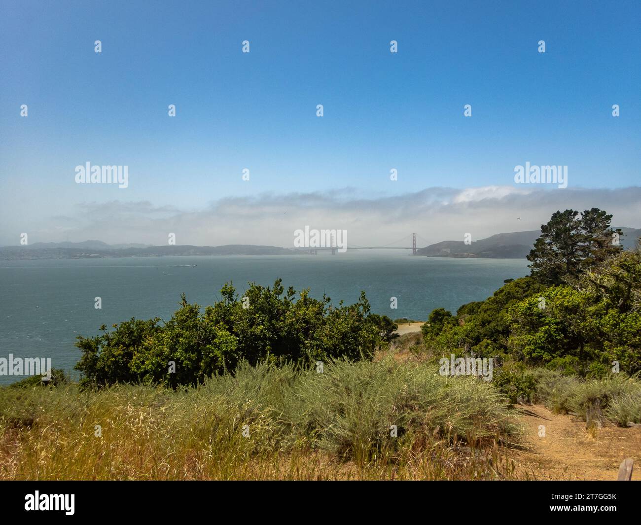 Mountain trail on Angel island looks out to vista of Golden Gate Bridge ...