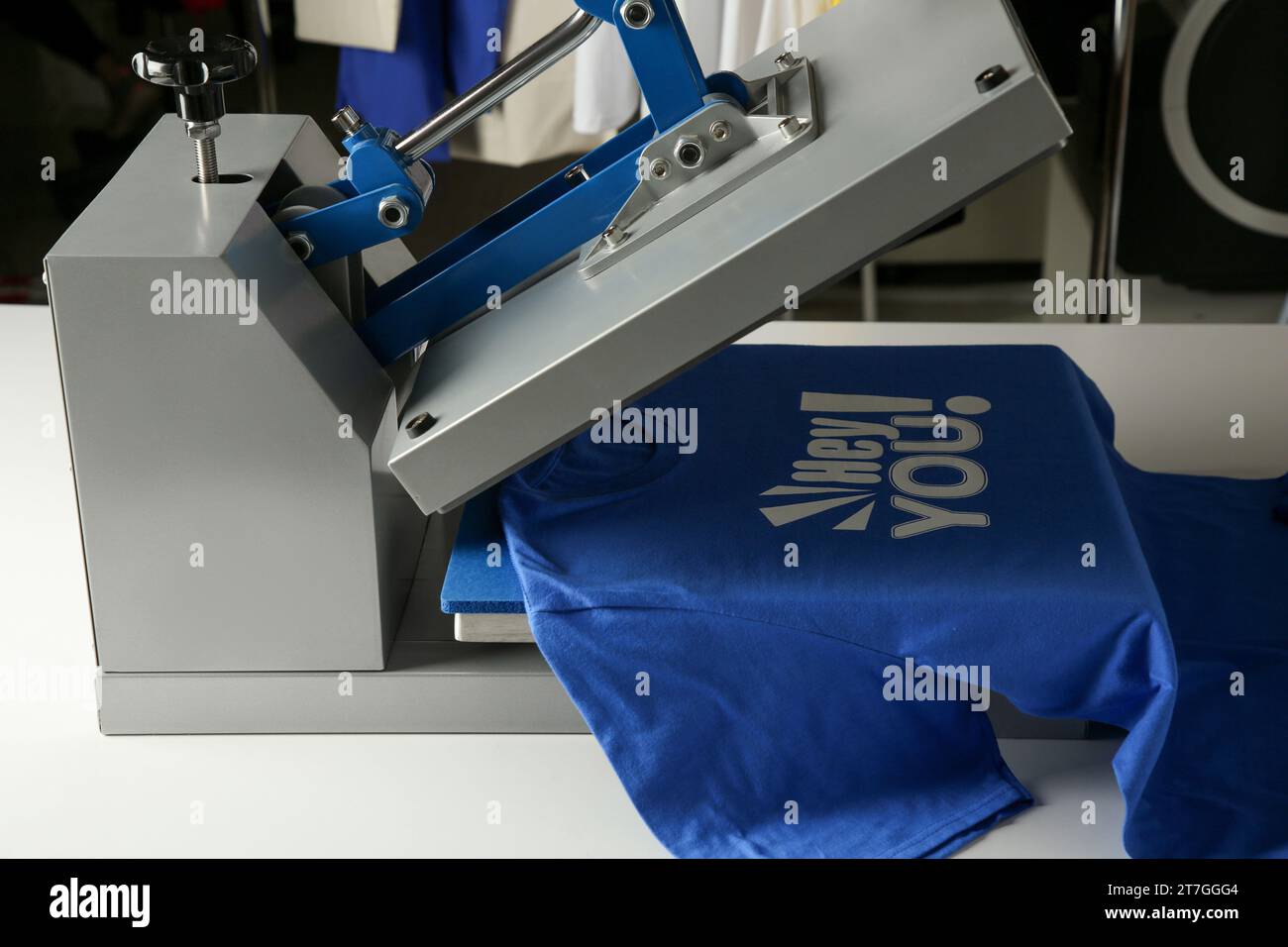 Printing logo. Heat press with blue t-shirt on white table Stock Photo ...