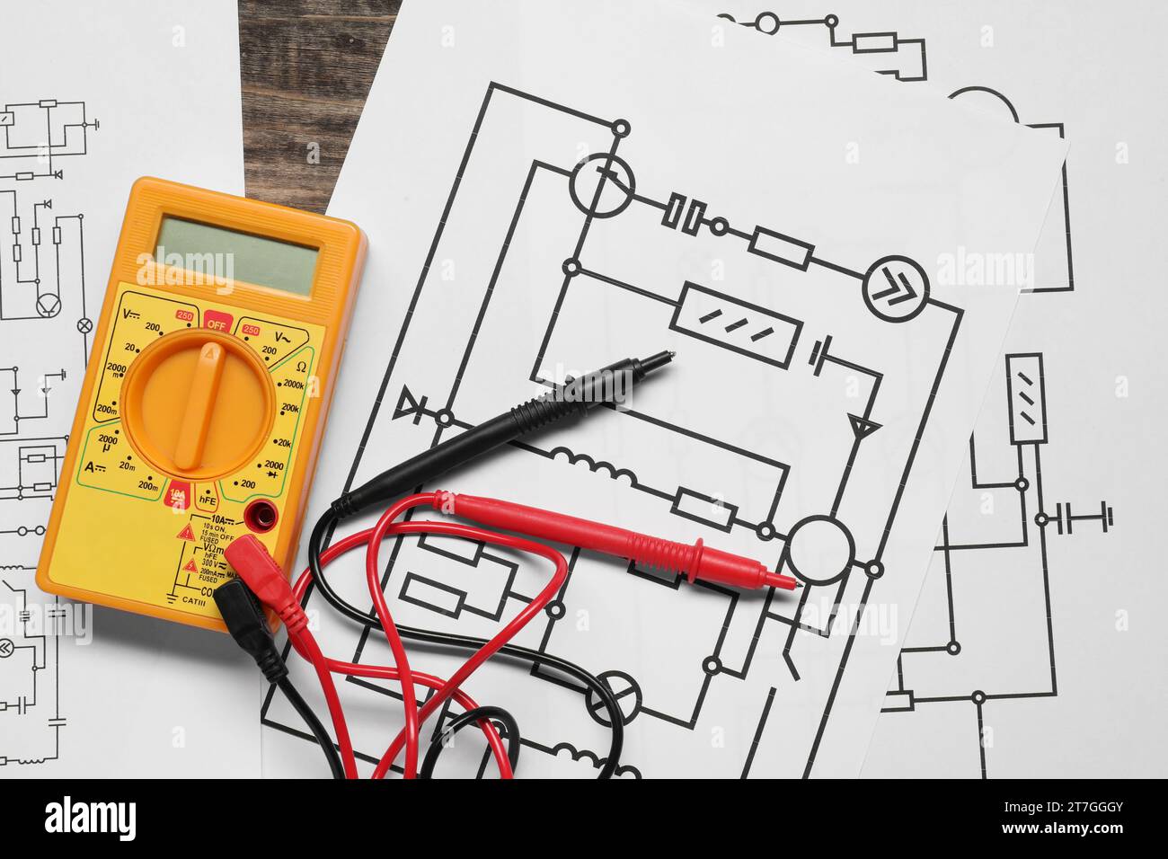 Wiring diagrams and digital multimeter on wooden table, flat lay Stock ...