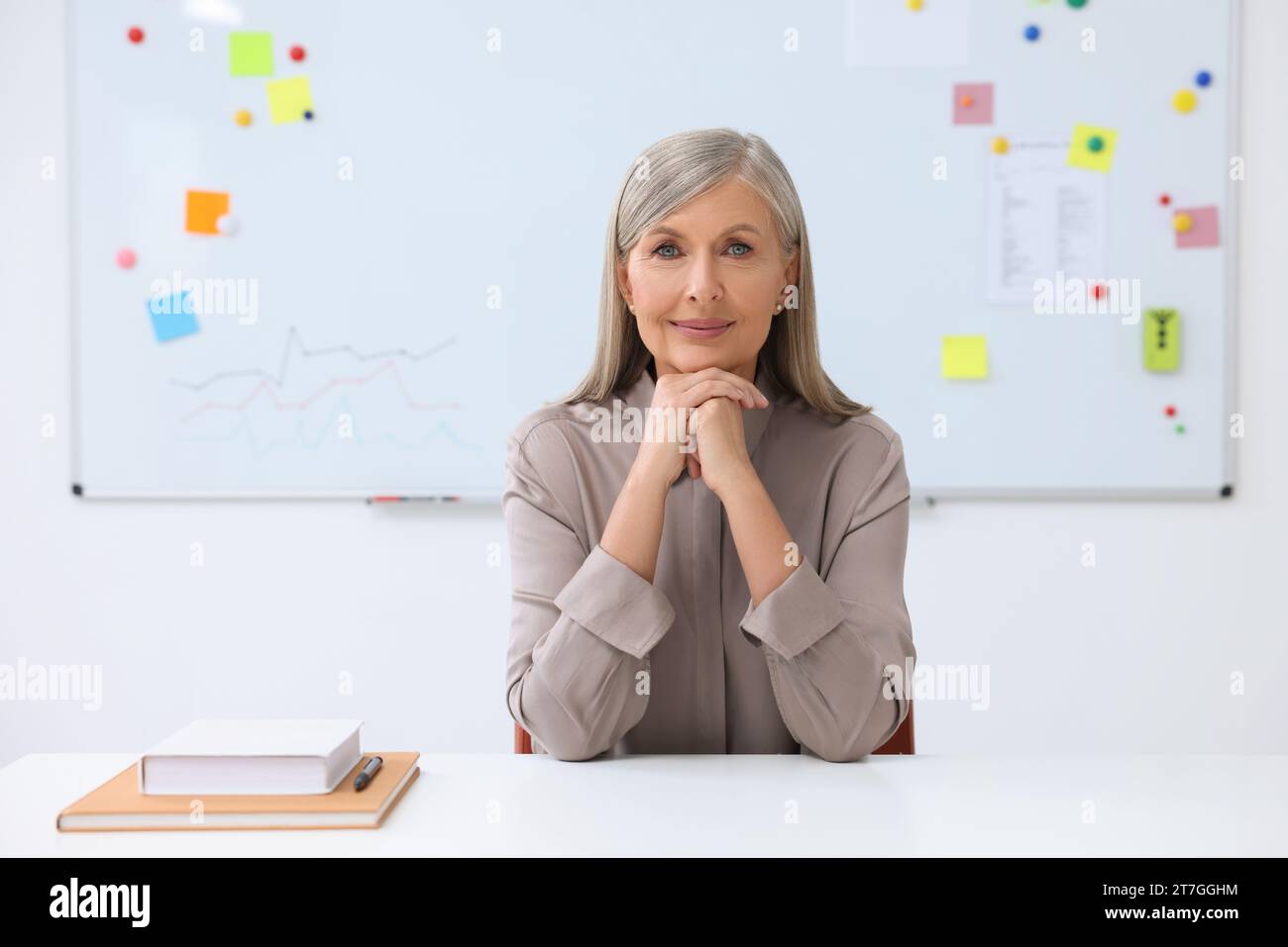 Portrait happy professor sitting desk hi-res stock photography and ...