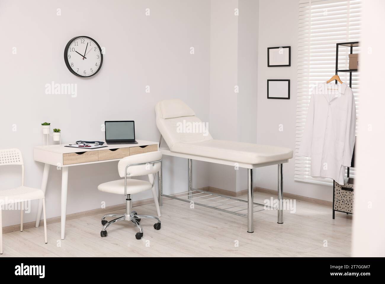 Modern medical office with doctor's workplace and examination table in ...