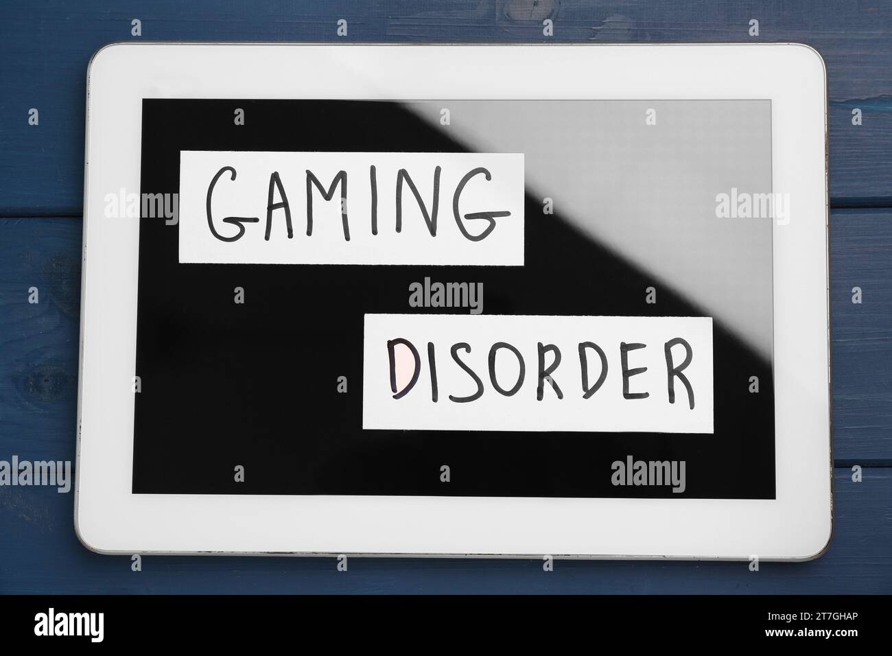 Tablet with phrase Gaming Disorder on blue wooden table, top view ...