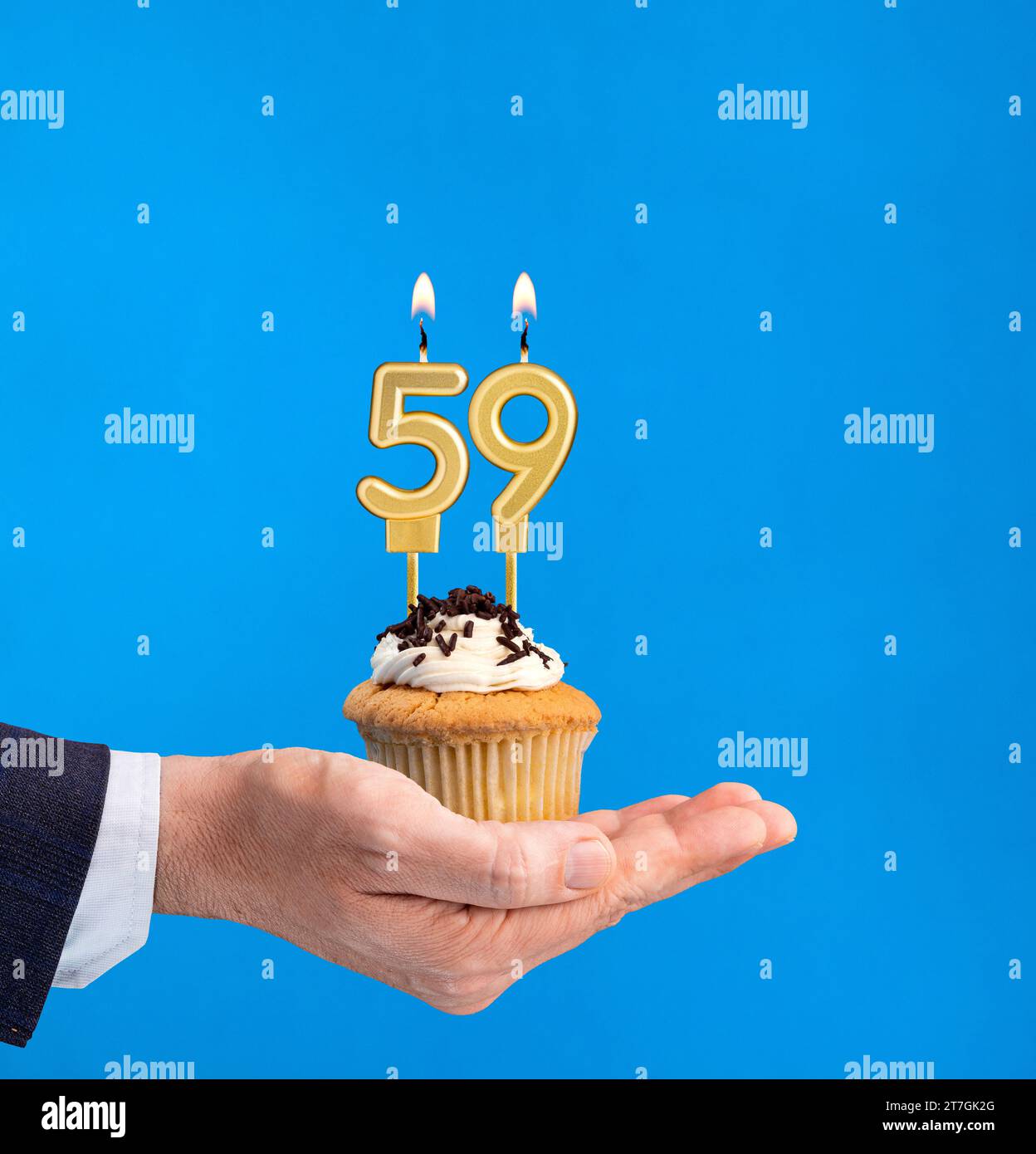 Hand holding a cupcake with the number 59 candle - Birthday on blue ...