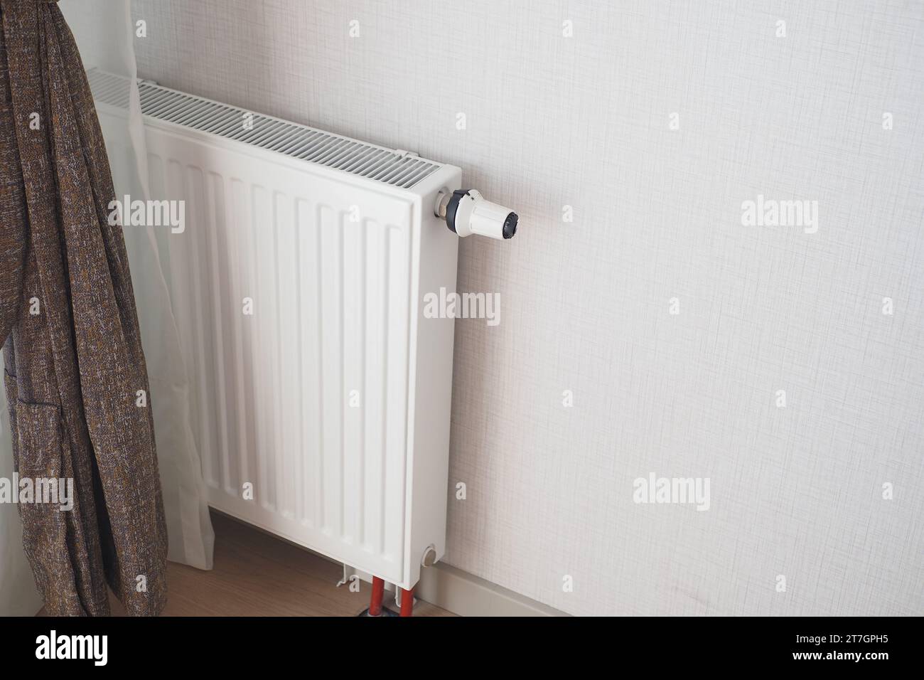 White radiator on grey white wall. apartment heating installation ...