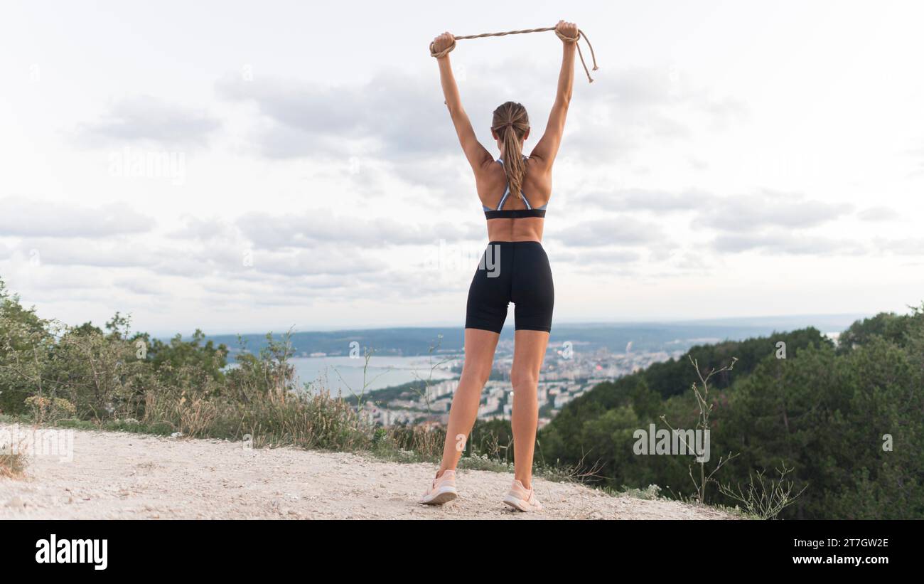 Back view woman holding rope up Stock Photo - Alamy