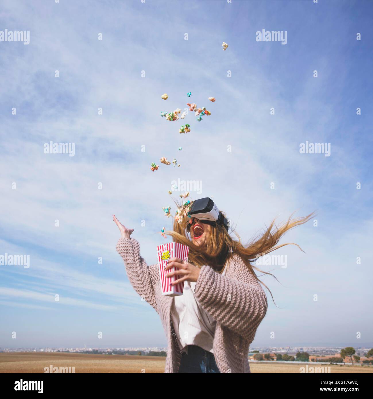 Bright girl vr glasses throwing popcorn Stock Photo - Alamy