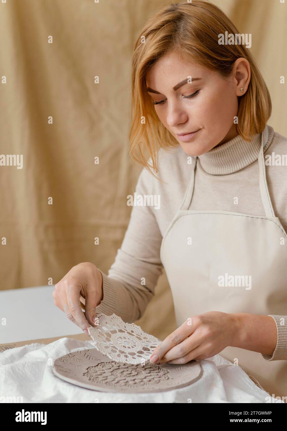 Close up woman decorating clay plate Stock Photo - Alamy