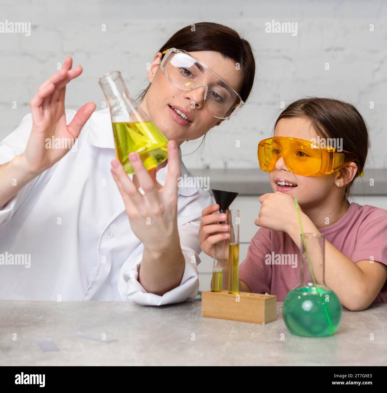 Female teacher girl doing science experiments with test tubes Stock ...
