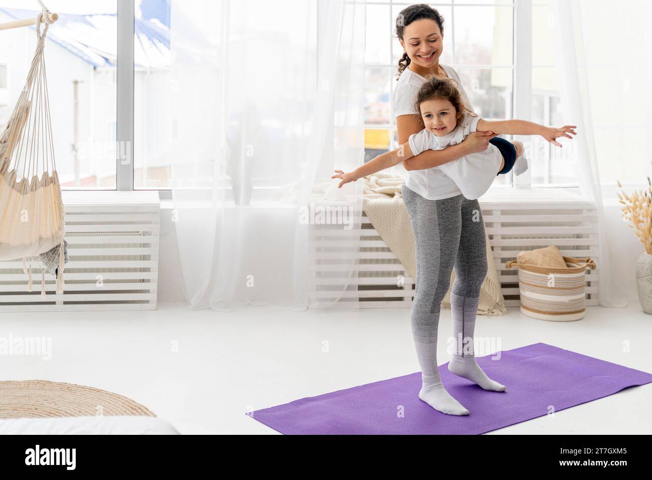 Full shot smiley woman training with kid Stock Photo - Alamy