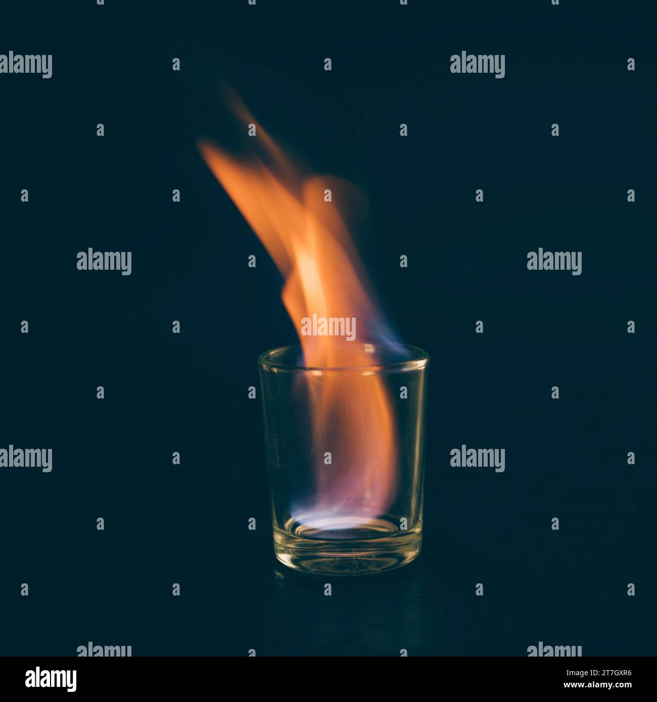 Glass with burning alcohol black background Stock Photo - Alamy