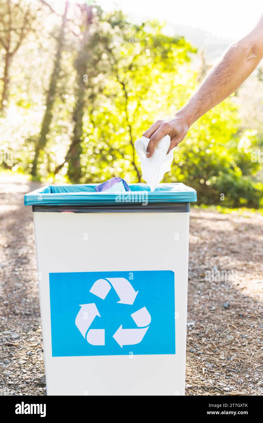 Hand throwing trash recycling bin Stock Photo - Alamy