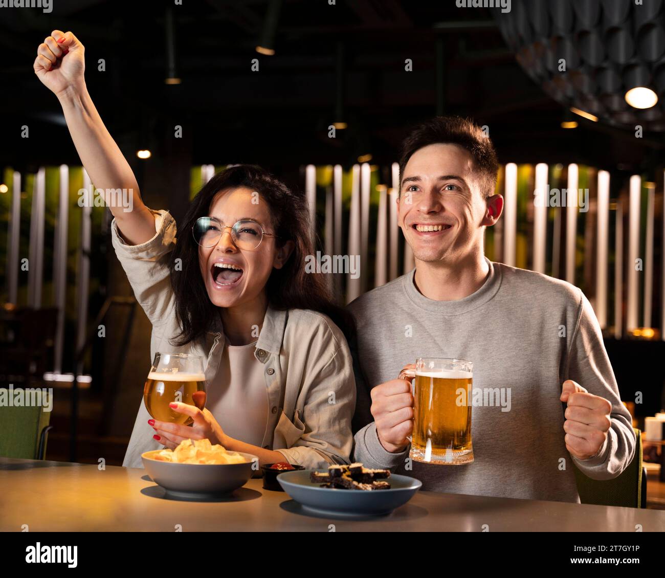 Medium shot cheerful friends pub Stock Photo - Alamy