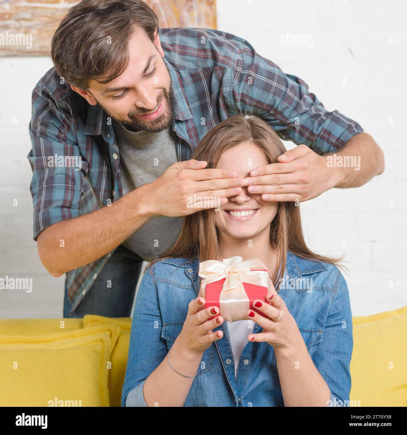 Man giving valentine gift girlfriend covering her eyes Stock Photo - Alamy