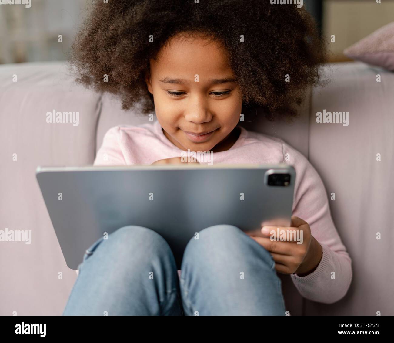 Little girl using tablet home Stock Photo - Alamy