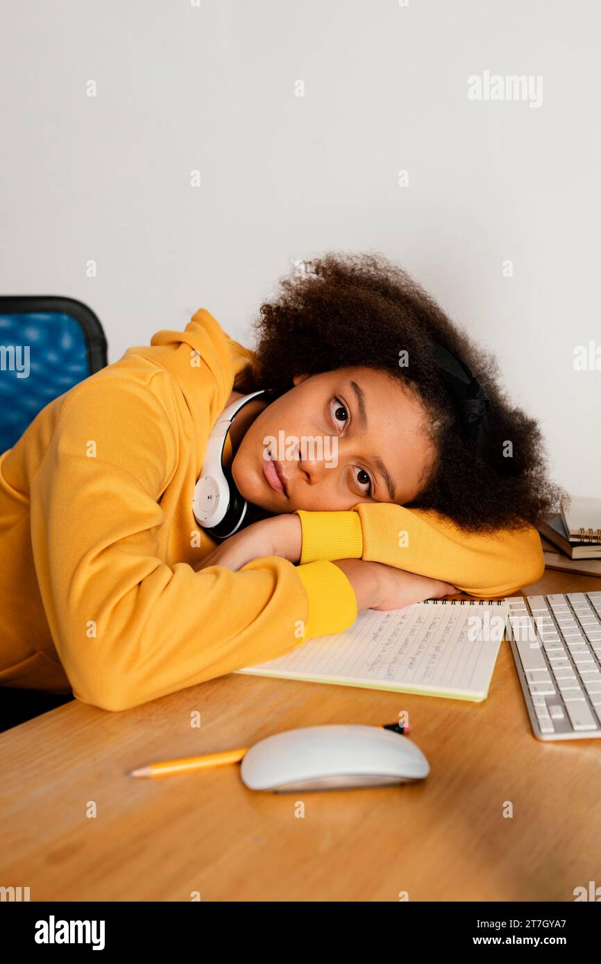 Medium shot girl laying desk Stock Photo - Alamy