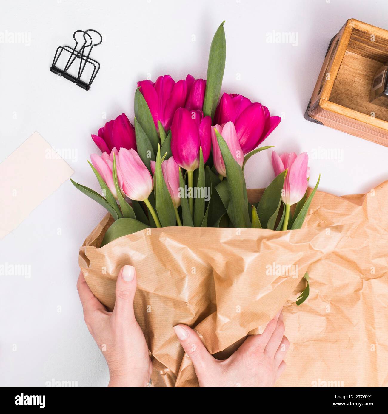 Person s hand making tulip flowers bouquet with brown paper isolated ...