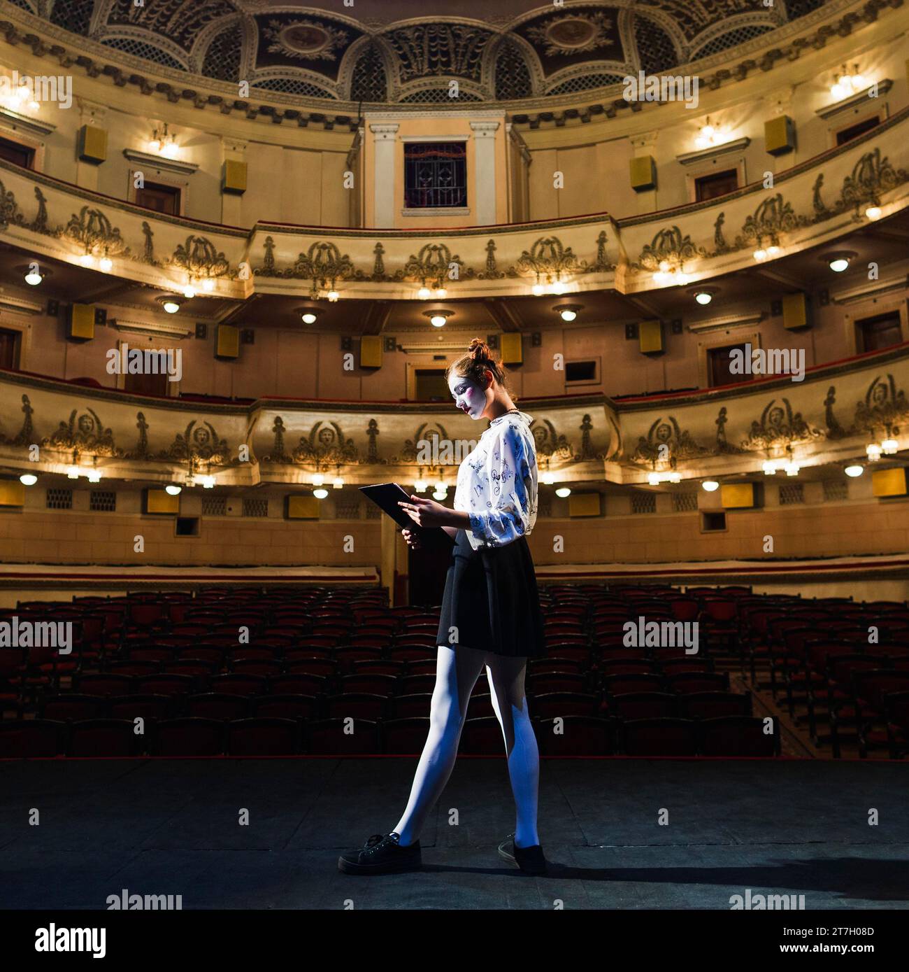 Side view female mime reading manuscript Stock Photo - Alamy