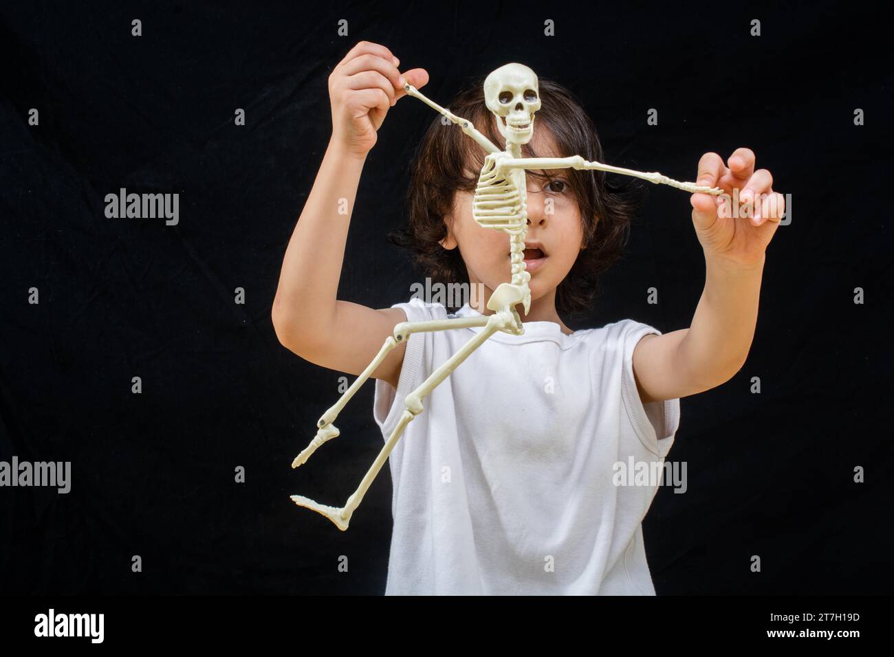 Little boy holding a small size artificial skeleton in hand Stock Photo ...