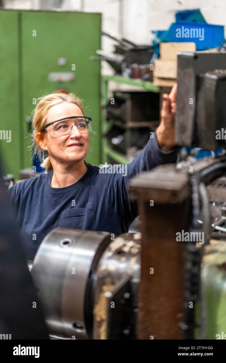 Female factory worker operator working in the control sector on a metal ...