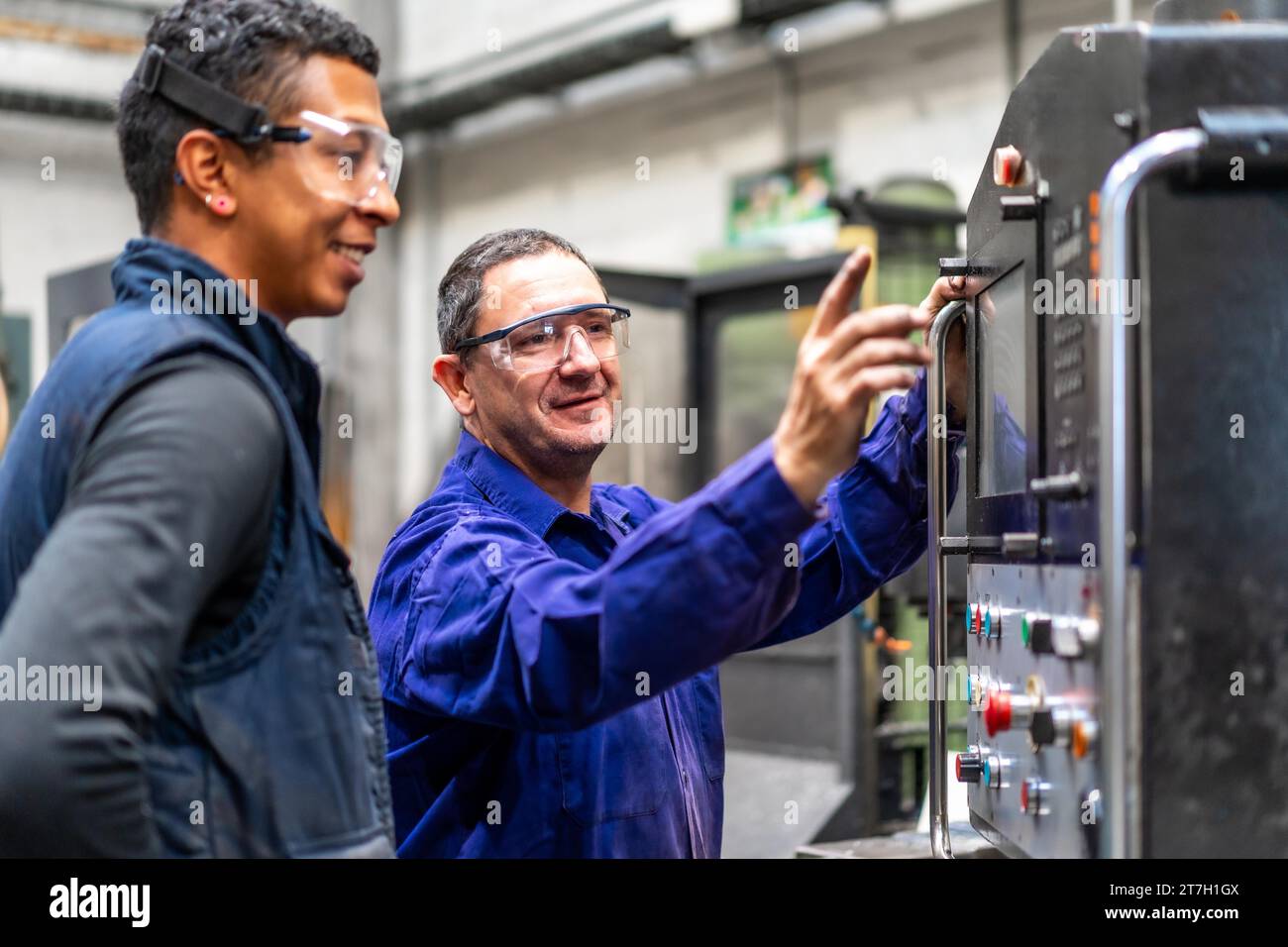 Instructor teaching the trade to a metal industrial factory worker in ...