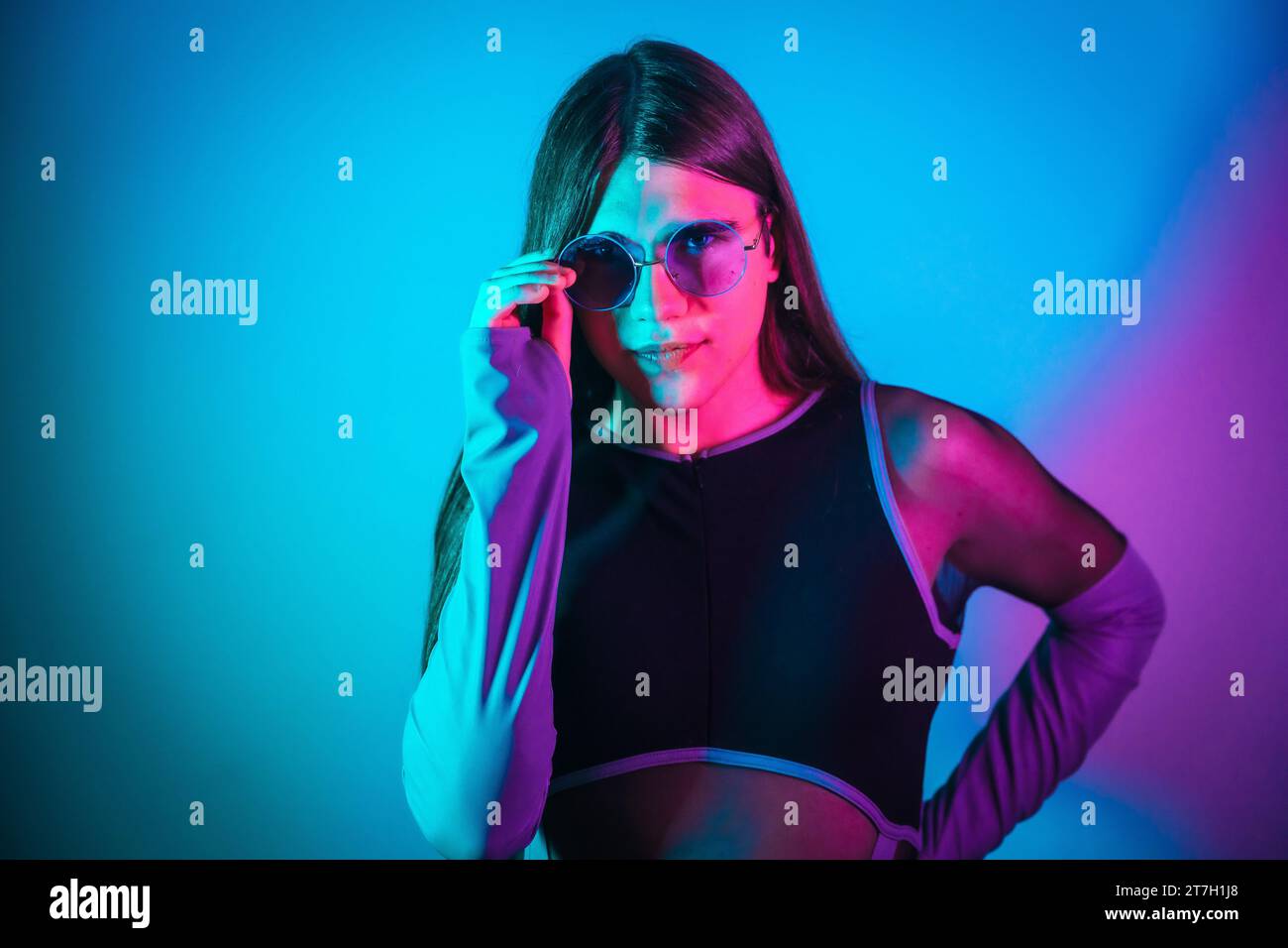 Portrait of cool and beautiful androgynous man illuminated by neon ...