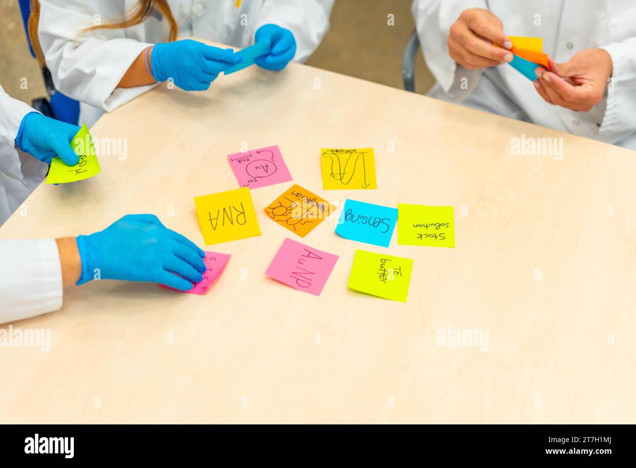 Close-up photo of group of scientists during a brainstorm study using ... Close-up photo of group of scientists during a brainstorm study using ...