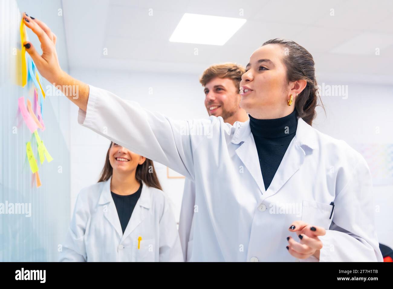 Three young biologists during a brainstorming meeting in a cancer ...