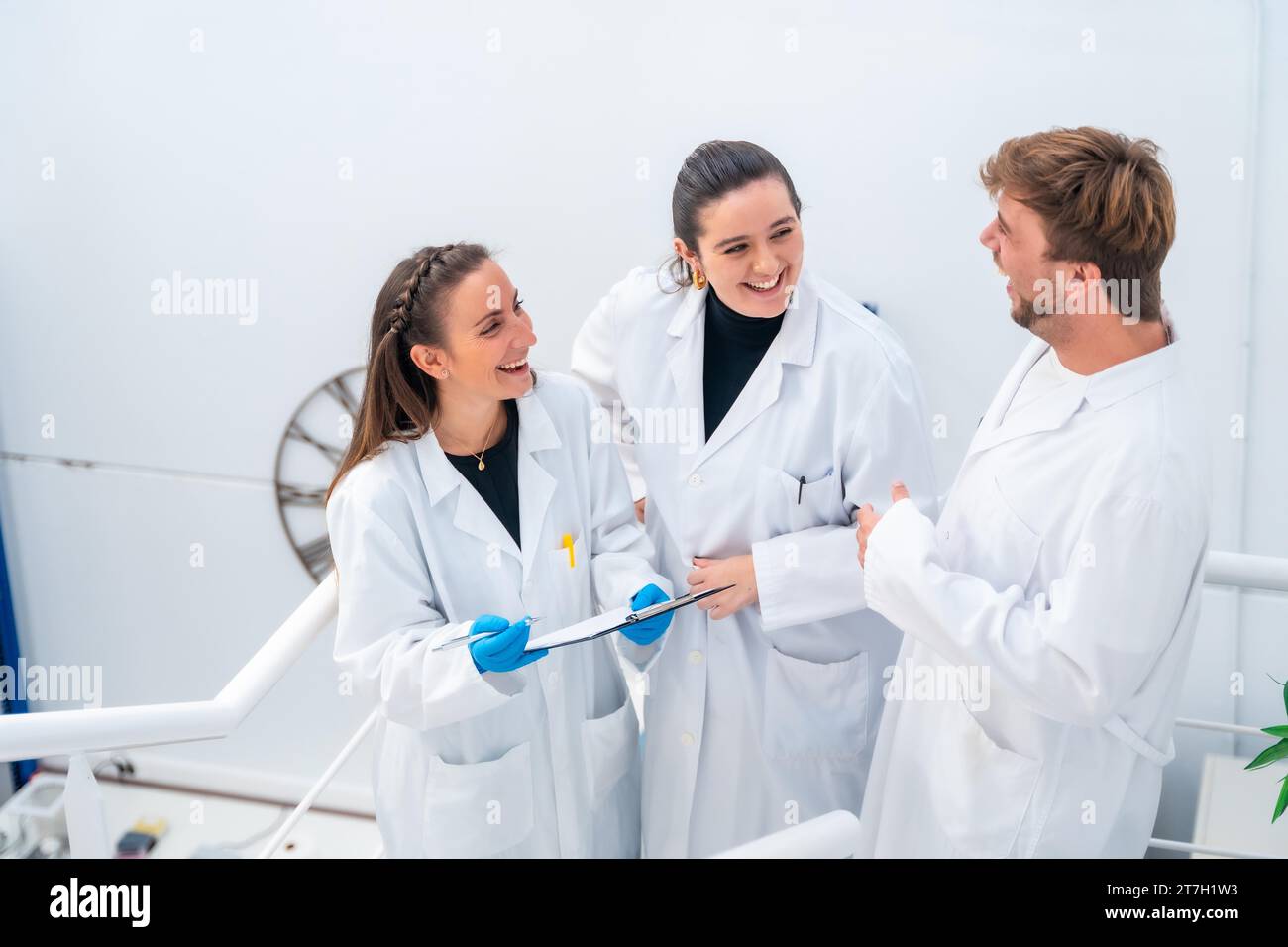 Side view and elevated view of three young scientists laughing while ...