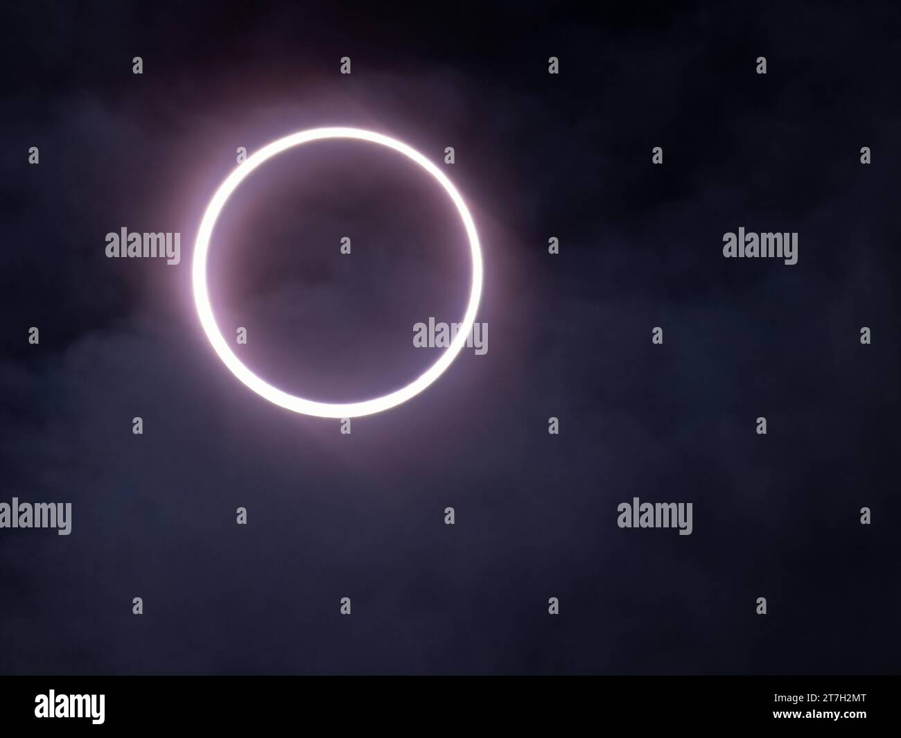 Annular eclipse of the sun by the moon with thin clouds in front of the ...