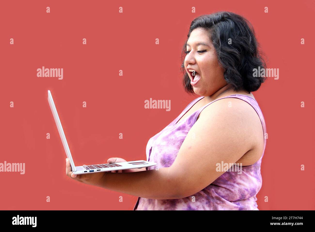 Young overweight 20 year old Latina brunette woman uses her laptop to ...