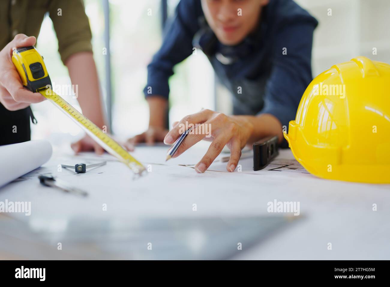 multi ethnic engineer brainstorming and measuring for cost estimating ...