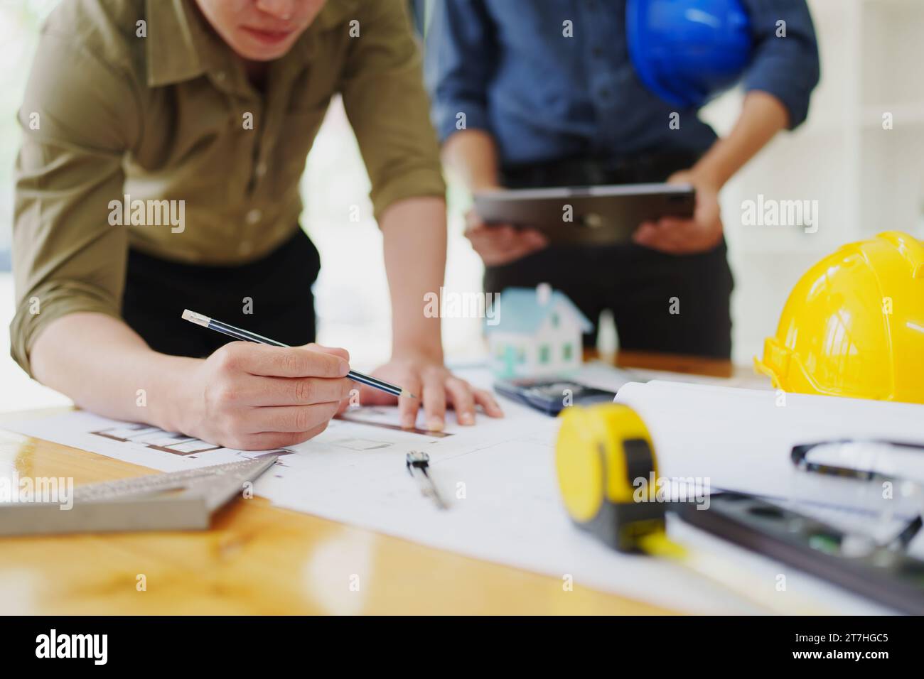 multi ethnic engineer brainstorming and measuring for cost estimating ...