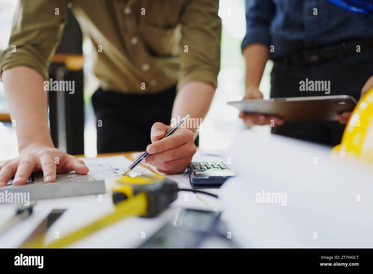 multi ethnic engineer brainstorming and measuring for cost estimating ...