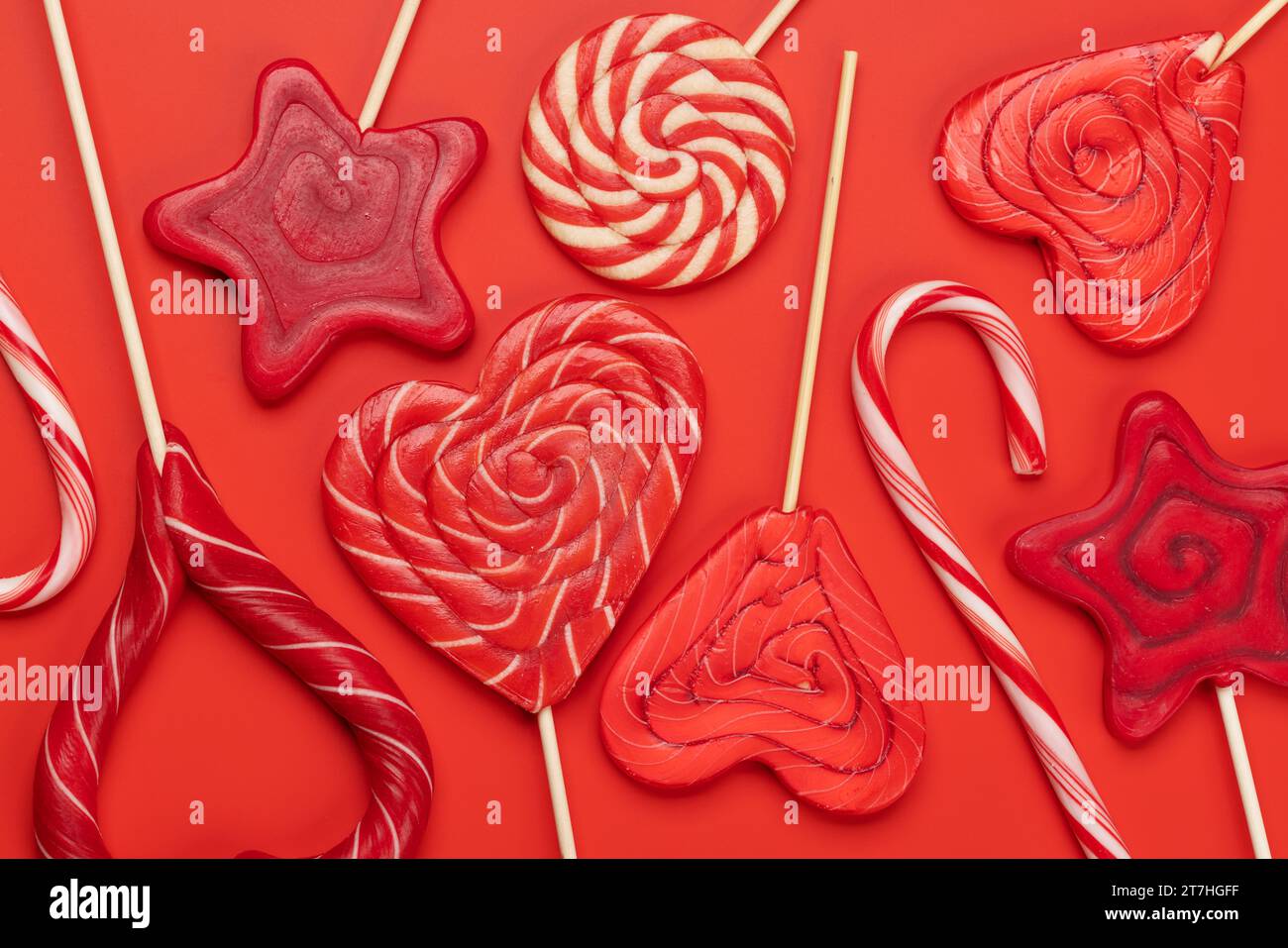 Various red candy sweets lollipops on red background. Valentines day ...