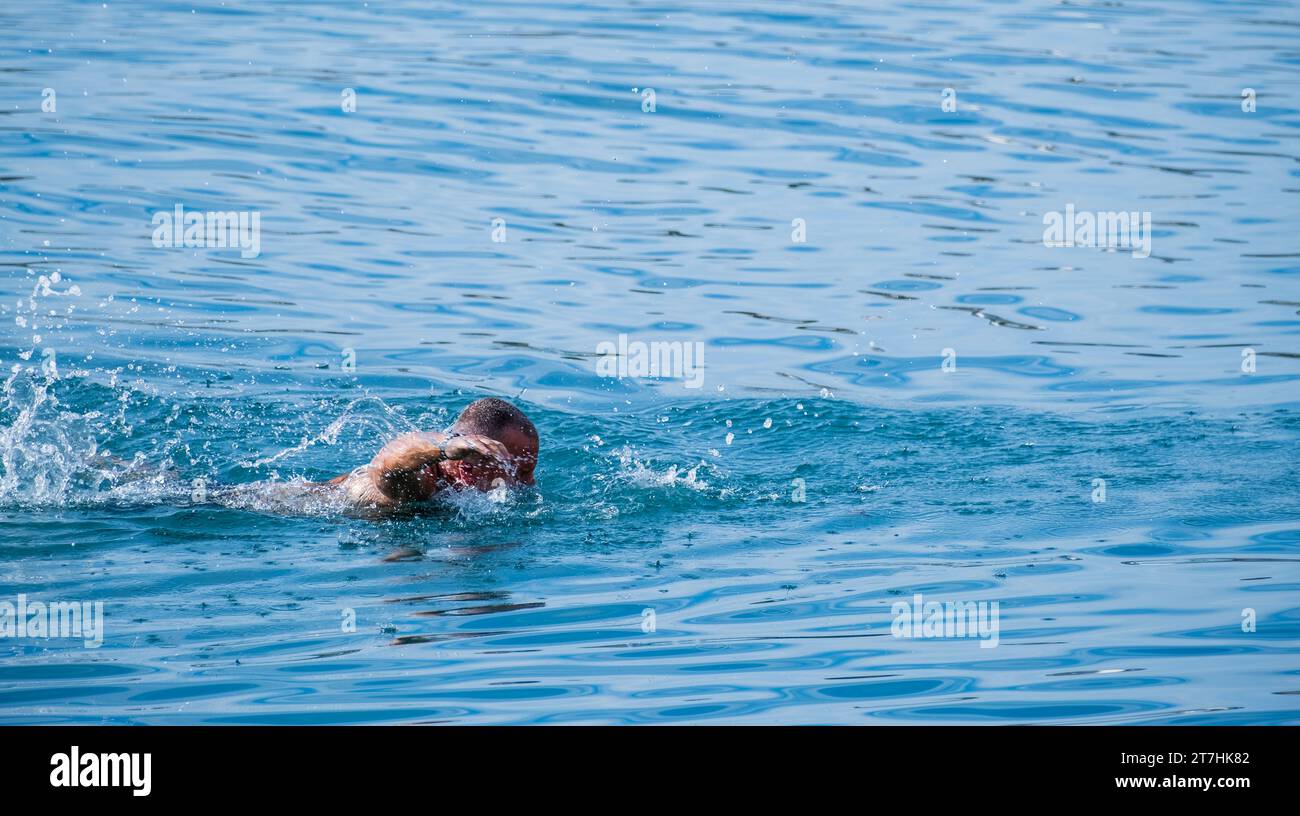 Senior man swimming in an outdoor swimming pool. Senior man swimming in ...