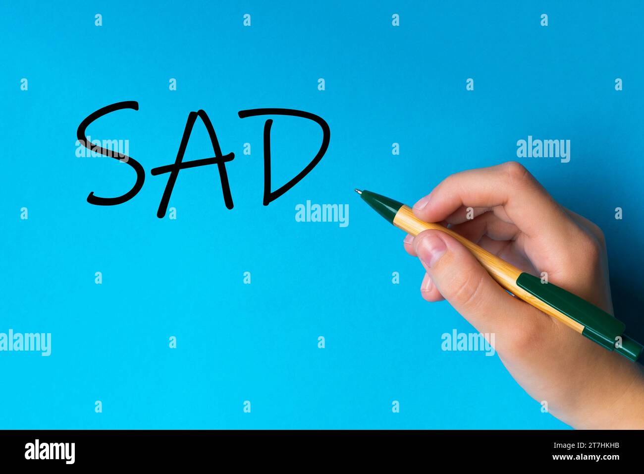 Children hand with pen write on an blue white background. Writing hand ...