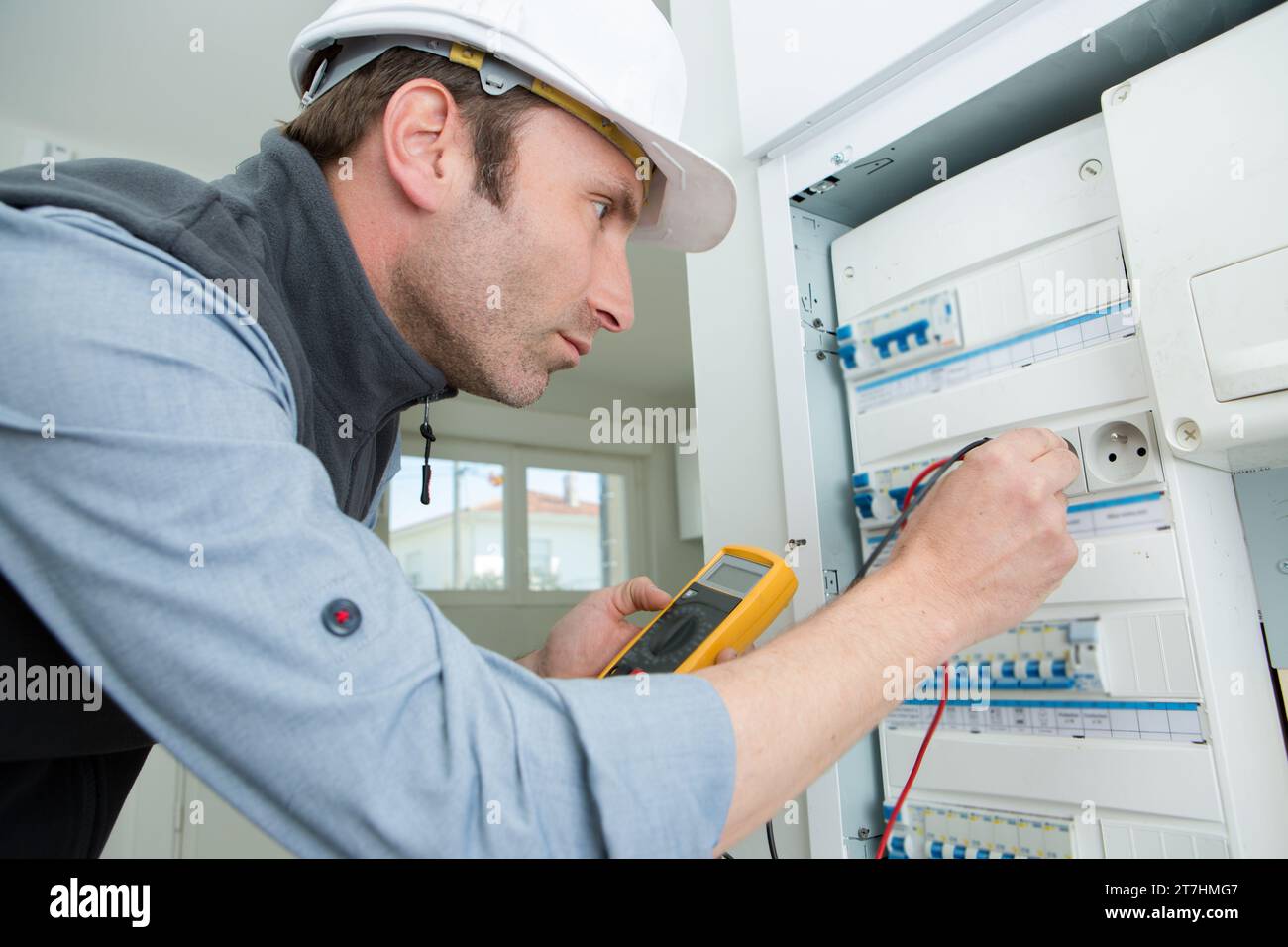 man using multimeter to test circuit-breaker box Stock Photo - Alamy