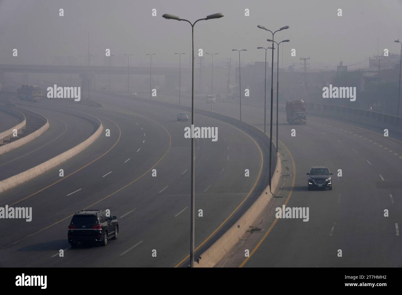 Vehicles go through traffic on a road as heavy fog reduces visibility ...