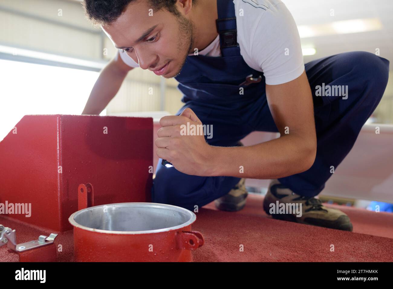 mechanic examining vehicle with torch at the repair garage Stock Photo ...