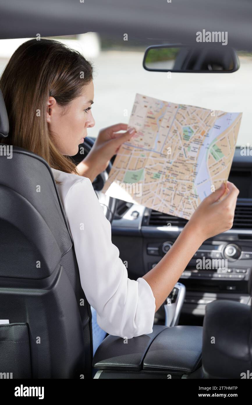female driver looking at a paper street map Stock Photo - Alamy