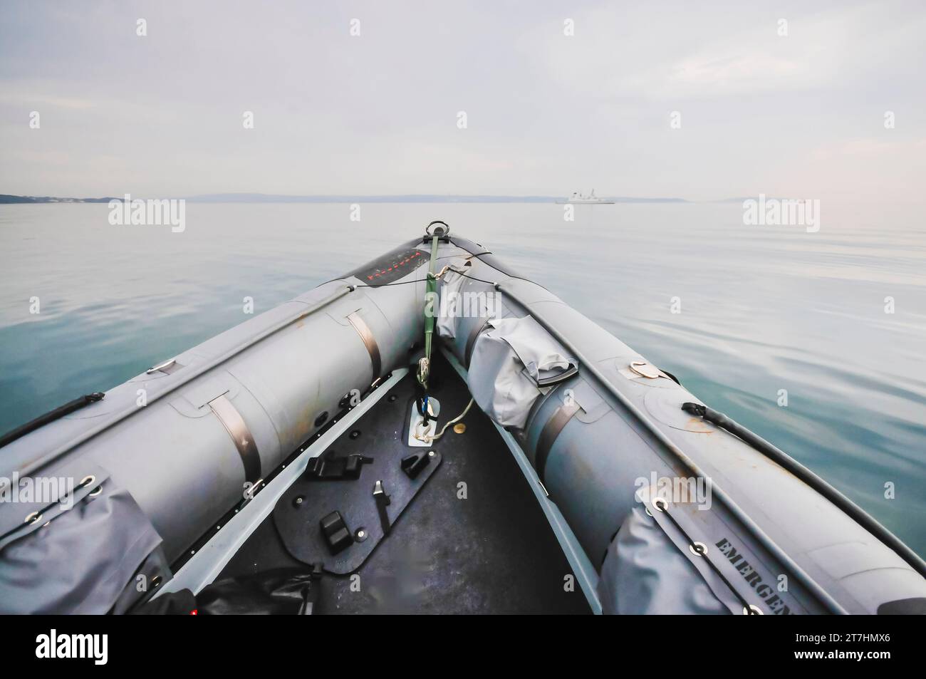 A Reinforced Inflatable Boat (RIB) is driven at speed across a flat sea ...
