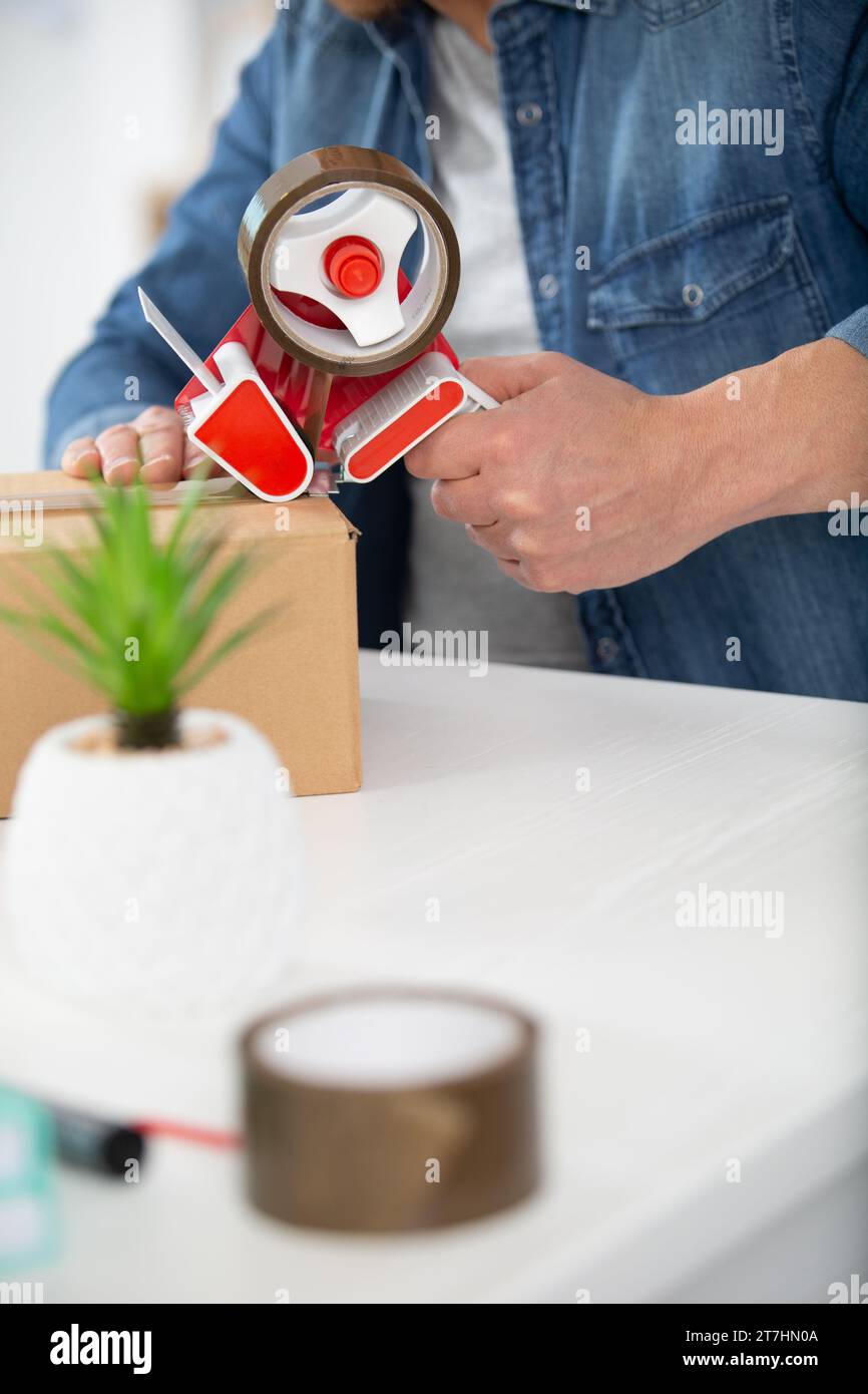 hands sealing cardboard boxes with duct tape Stock Photo - Alamy